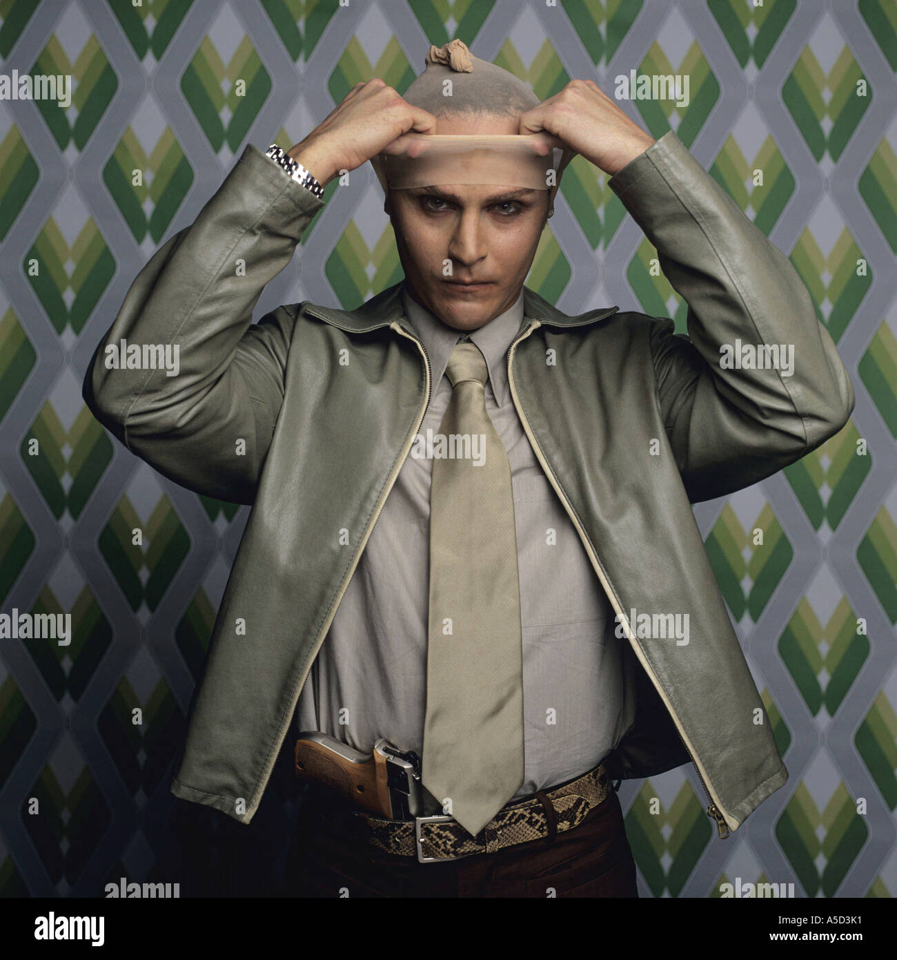 Armed man pulling mask over his face, portrait Stock Photo - Alamy