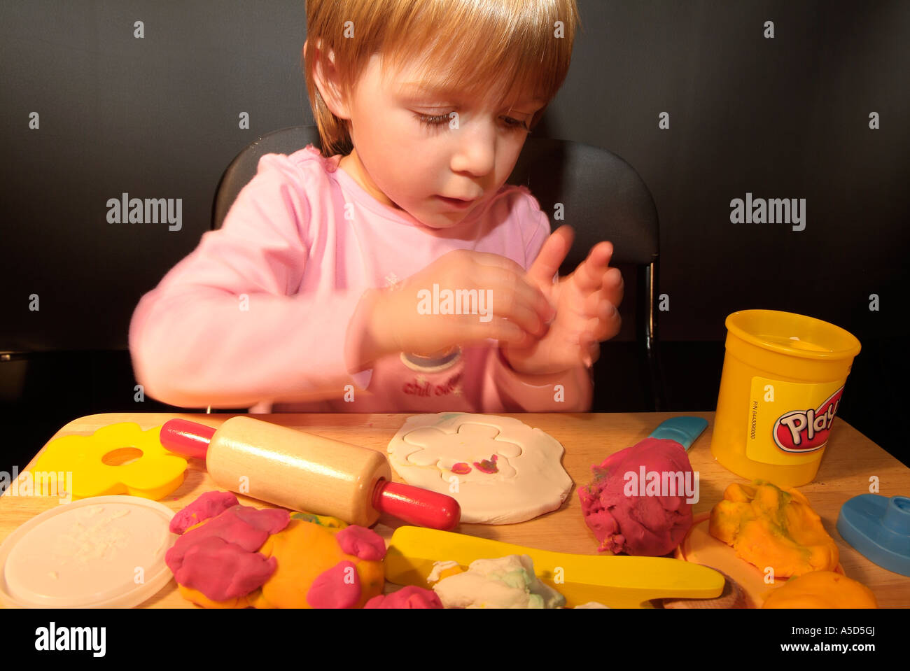 Young girl playing with modeling clay Stock Photo - Alamy