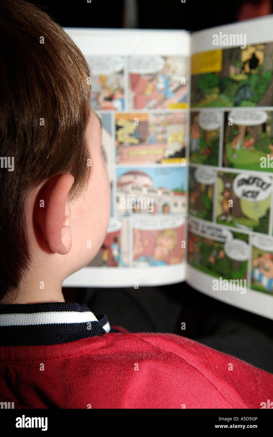 Young boy reading a comic strip Stock Photo - Alamy