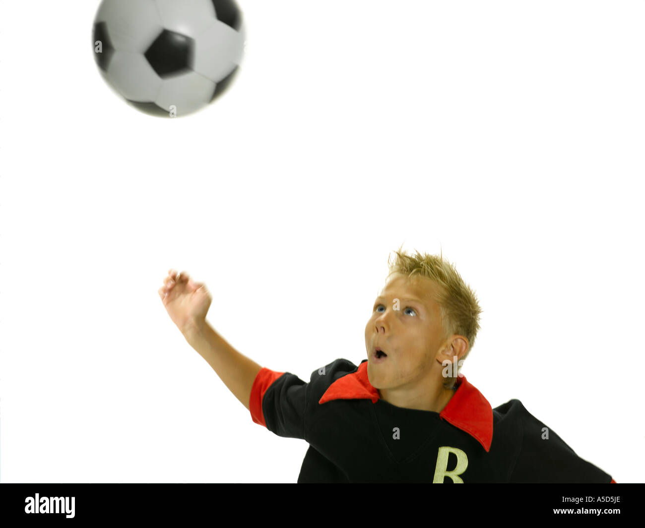 Young boy heading a football Stock Photo - Alamy