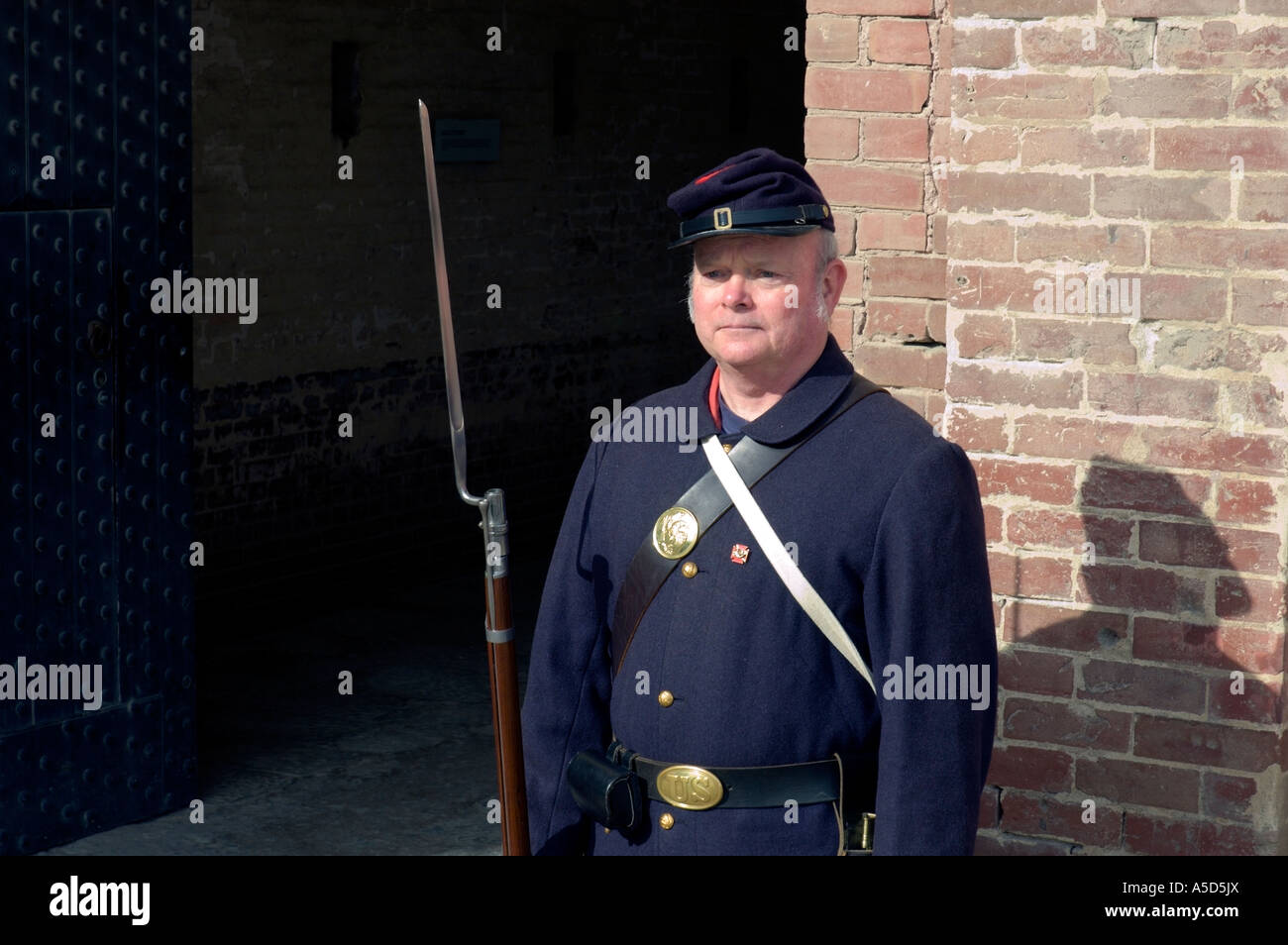 A Union reenactor in a blue coat and kepi stands with a bayoneted ...