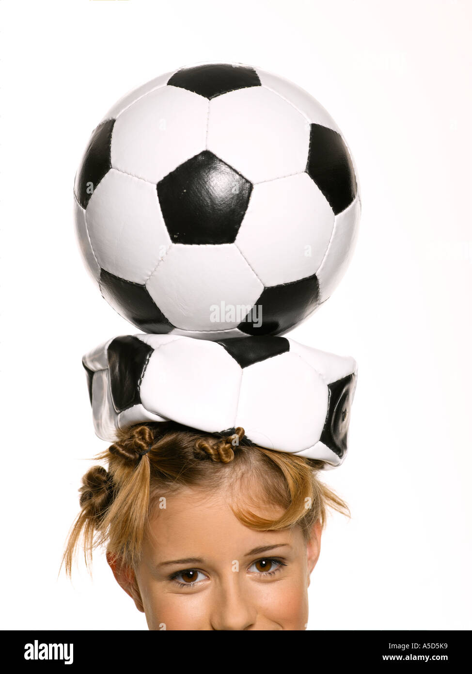 Girl balancing football on her head Stock Photo - Alamy