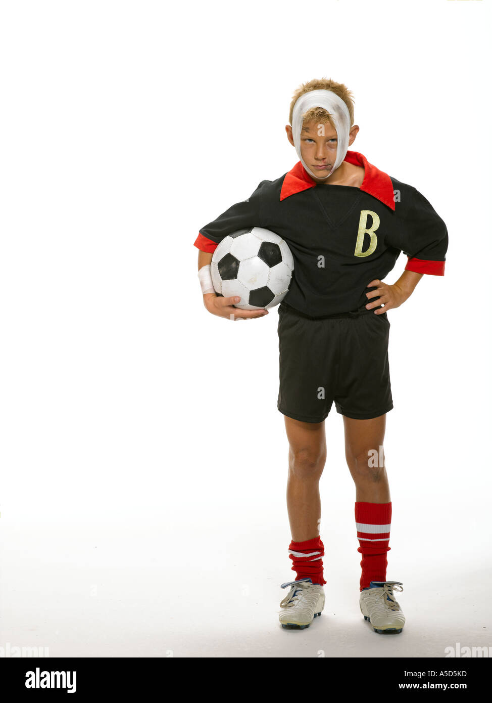Boy (8-11)holding soccer ball underarm with bandage on head Stock Photo ...