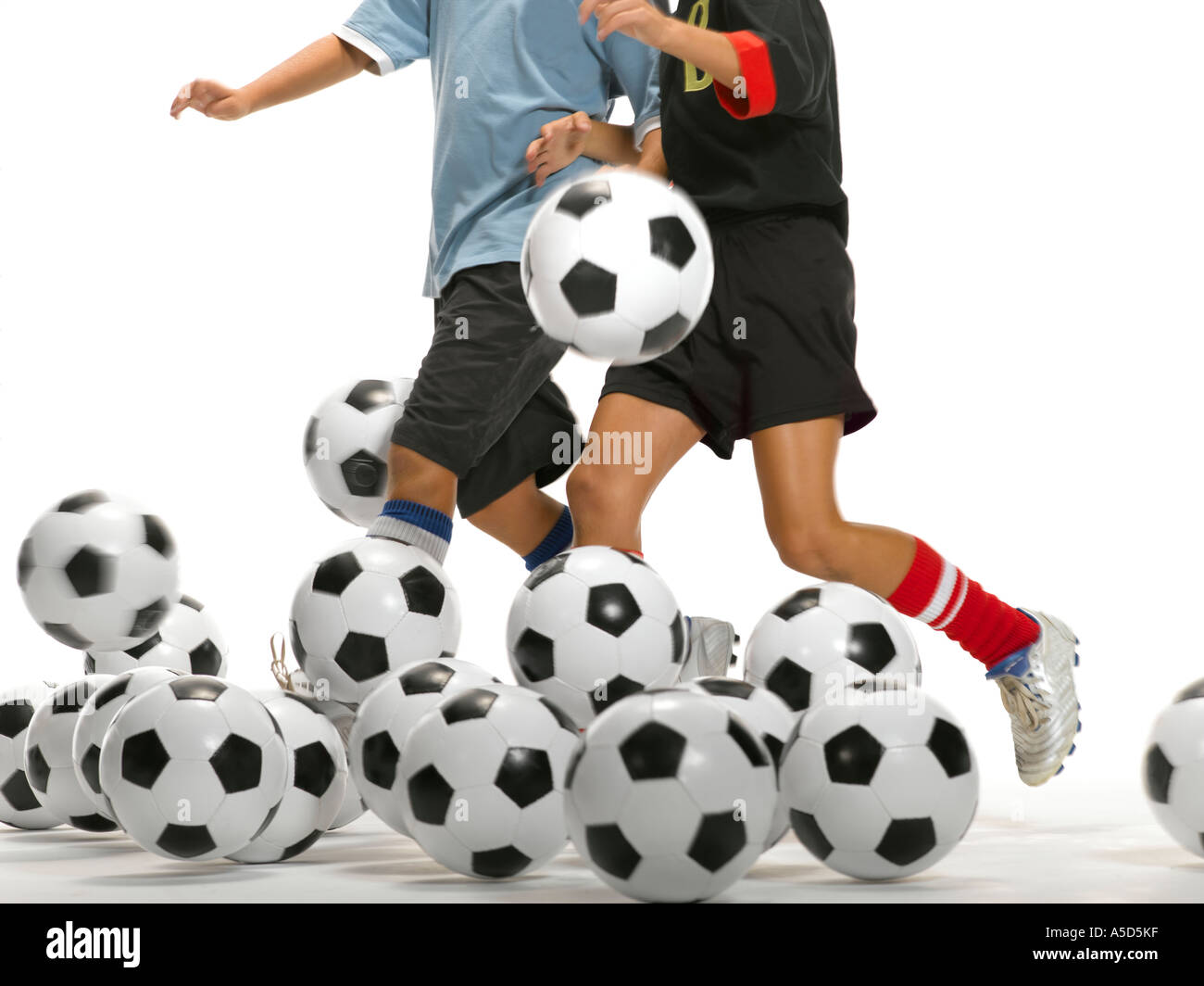 Two kids kicking footballs Stock Photo - Alamy