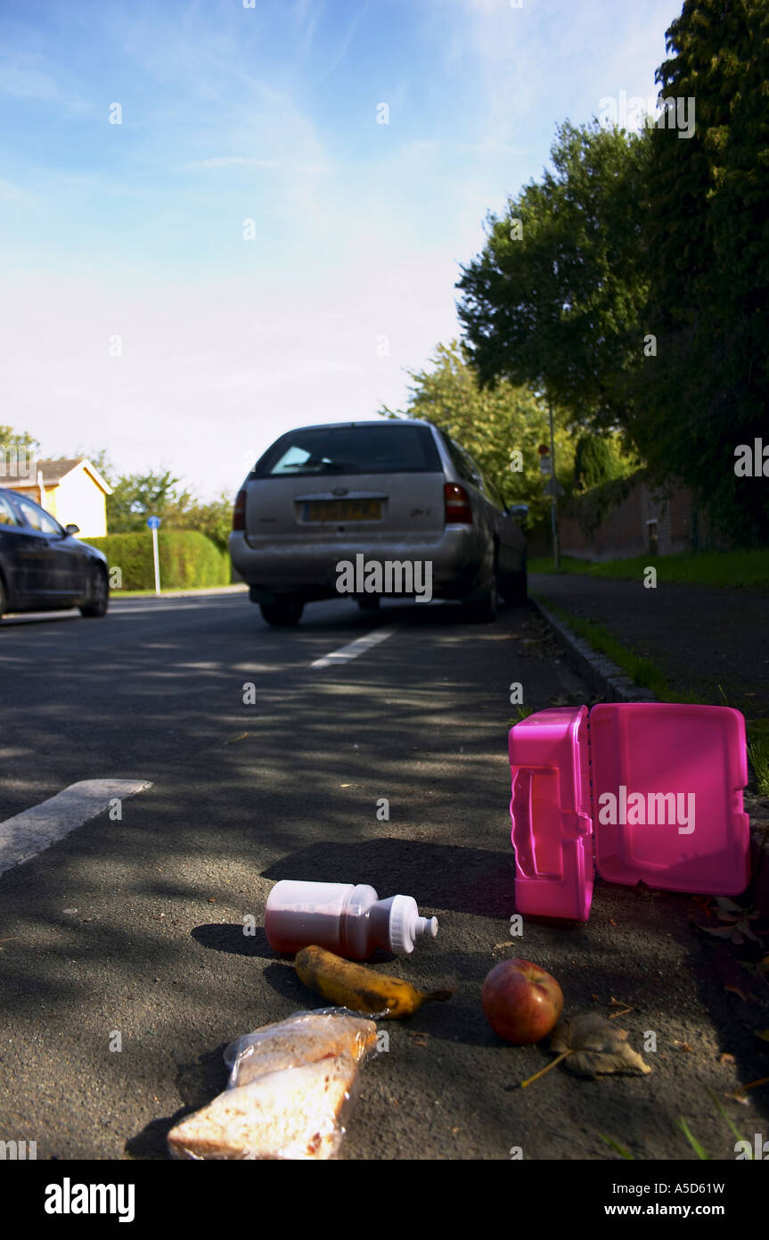 Car pulled up at kerb with dropped or discarded lunchbox suggesting ...