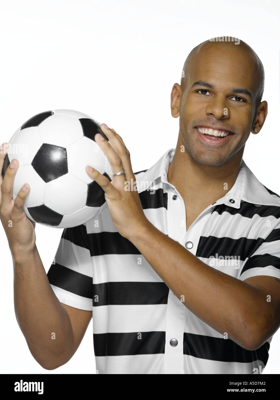 Young man holding football, smiling Stock Photo - Alamy
