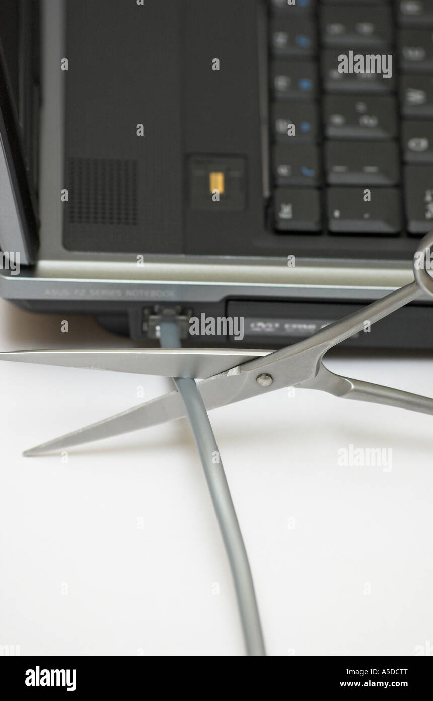 Scissors cutting telephone cable on laptop computer Stock Photo - Alamy