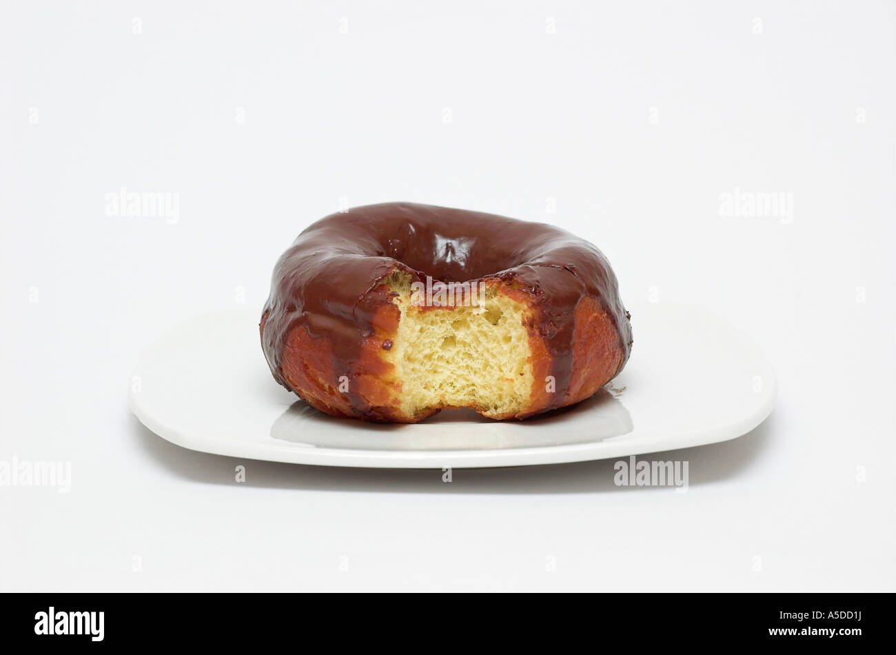 Chocolate doughnut with missing bite on plate close up Stock Photo - Alamy