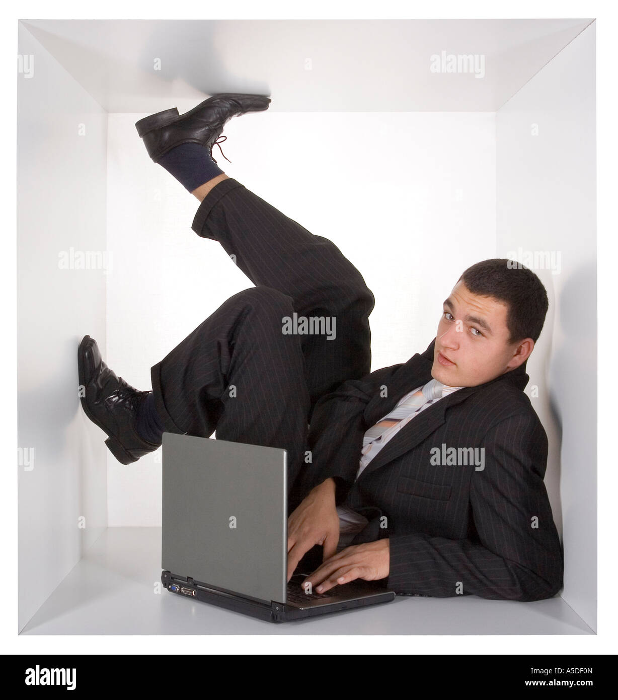 businessman with laptop in the cramped white cube Stock Photo - Alamy