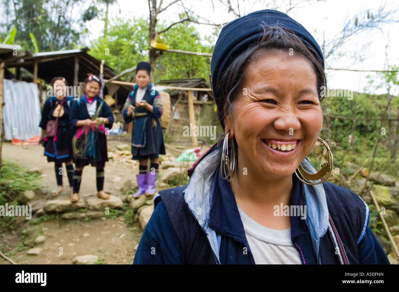 A Black Hmong tribeswoman laughs while her friends look on in Sapa ...
