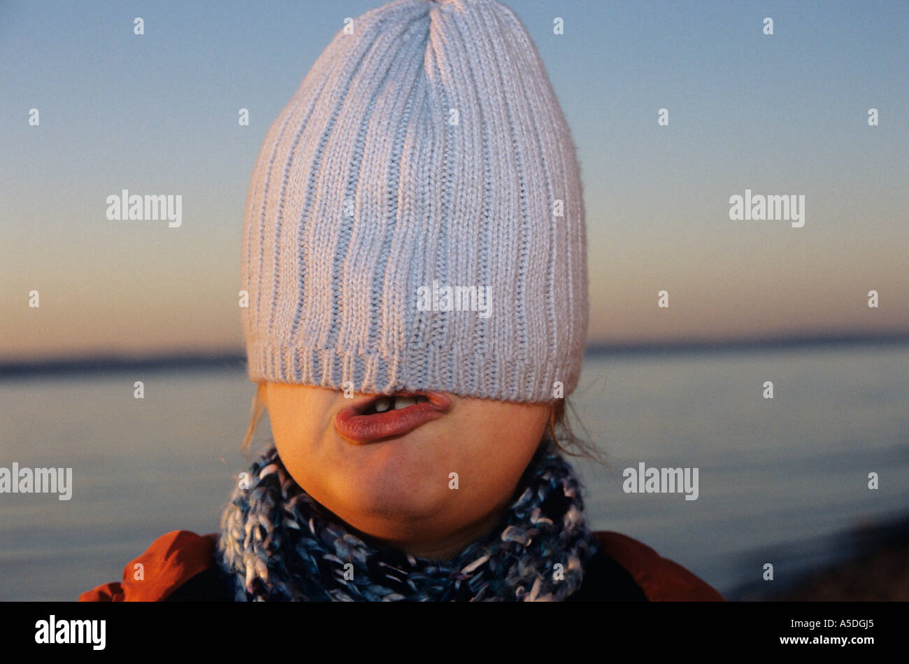 Girl hiding under cap Stock Photo - Alamy