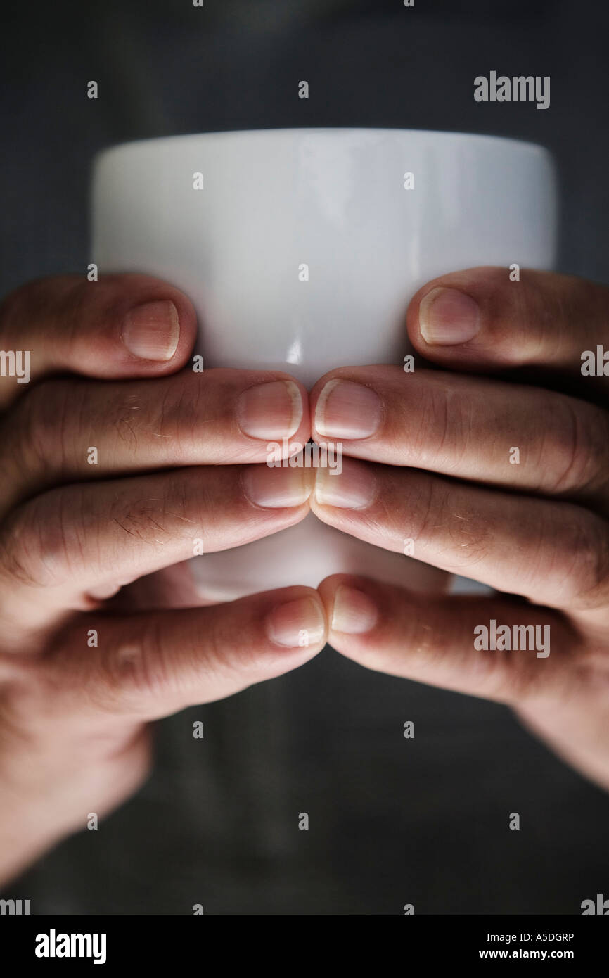 Man holding a white cup with both hands Stock Photo - Alamy