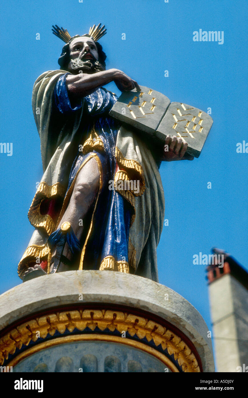 16th Century colourful painted statue on top of historical street ...