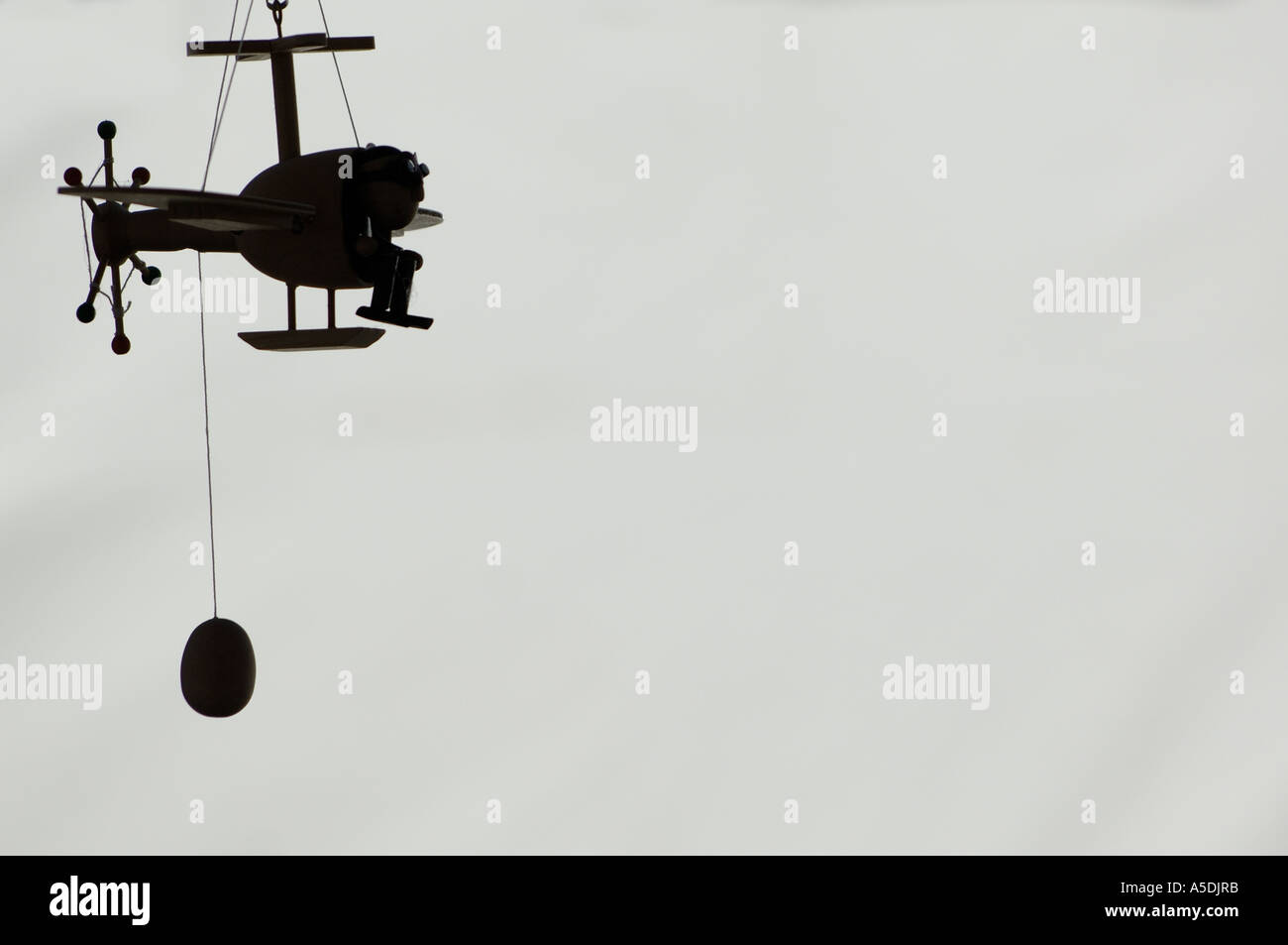 Silhouette of handcrafted toy hanging from ceiling over white ...
