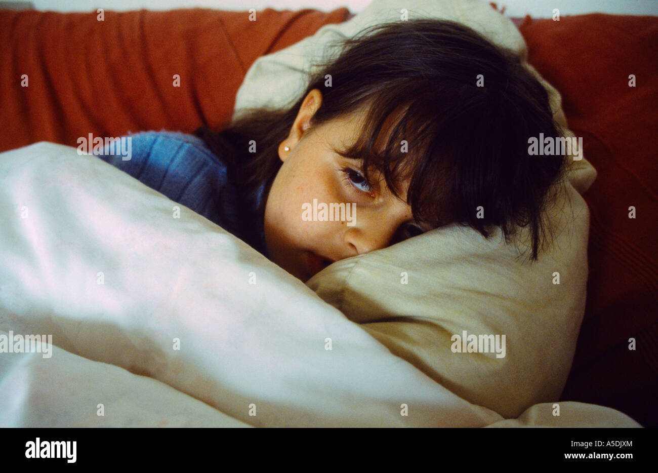 Sick Child Laying On Sofa Looking Dizzy Stock Photo - Alamy