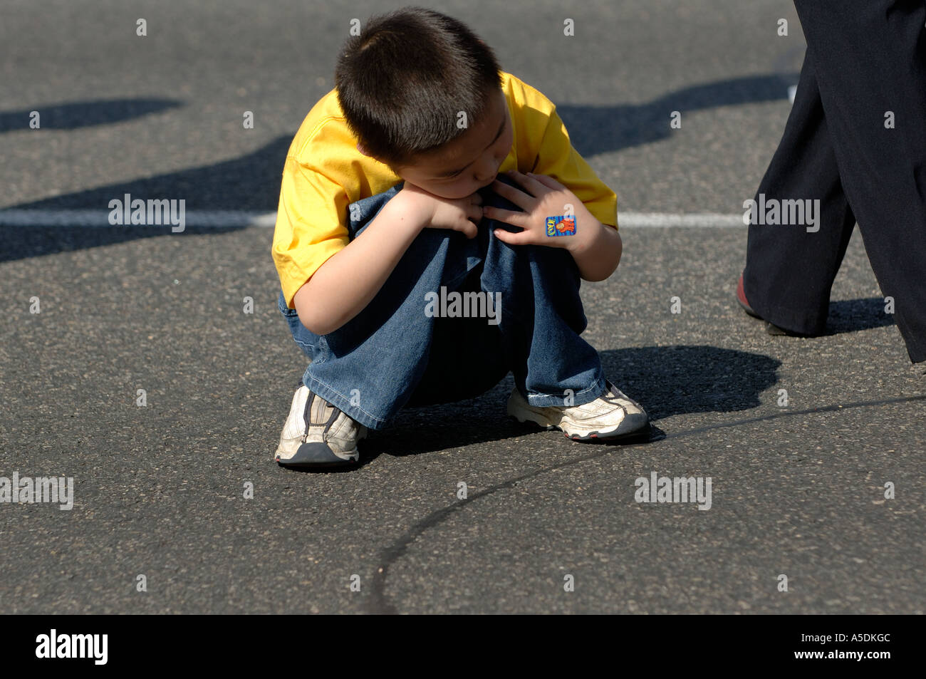 Asian boy resting in squat position at the Chinese Lantern Festival ...