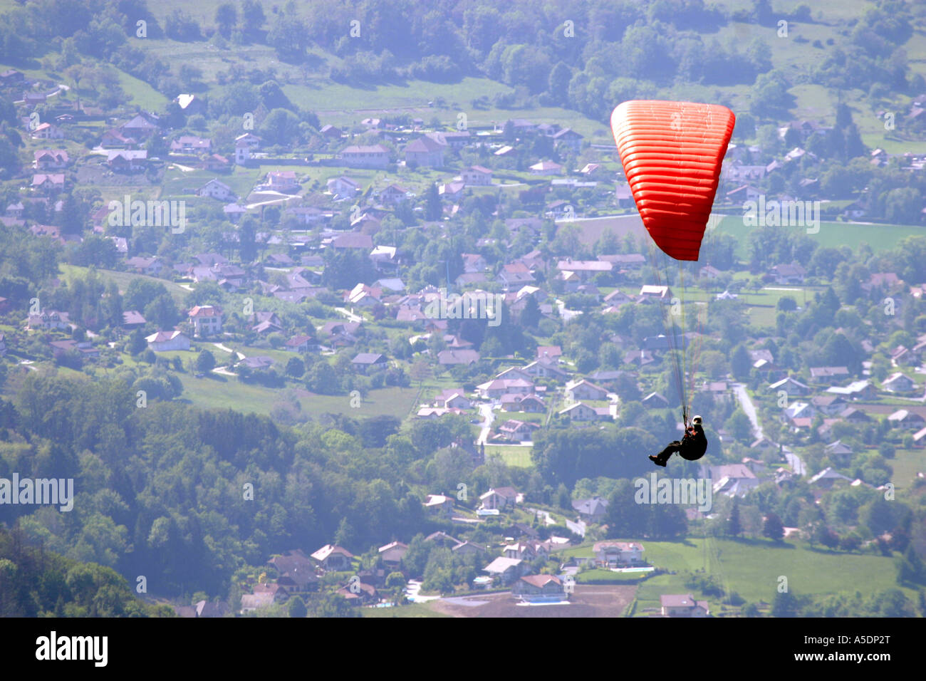 A red paraglider flying over Annecy, France, Europe Stock Photo - Alamy