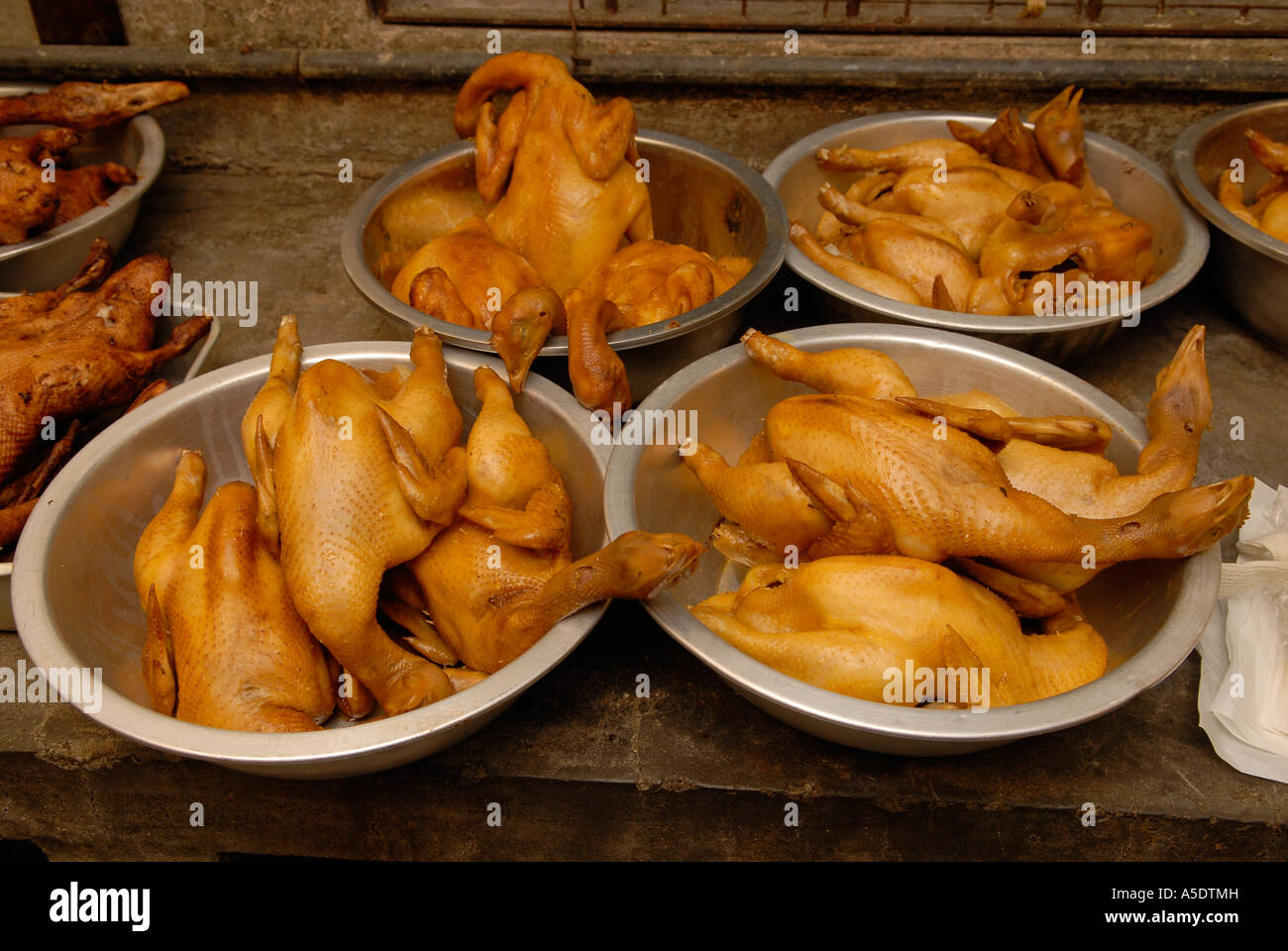 Fresh raw whole chicken in metal bowl ready to be roasted in a kitchen ...