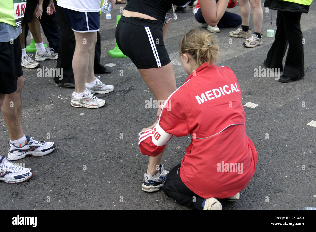 physio attention for cramp at The Flora London Marathon Stock Photo - Alamy