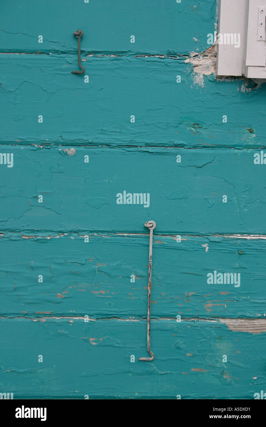 Two hooks one short and the other long hang on the side of a brightly ...