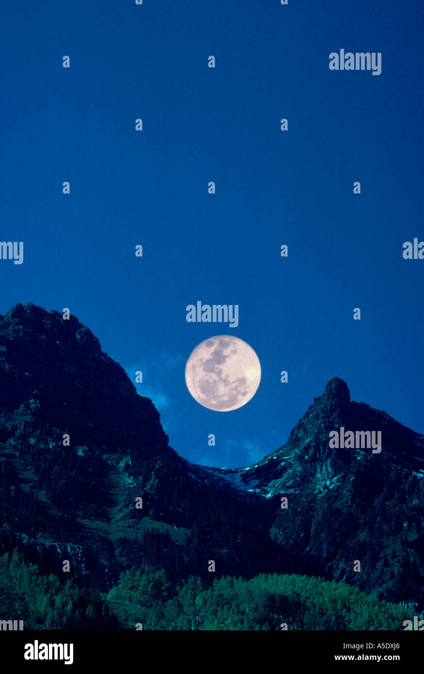 full moon rising between mountain peaks moonlight San Juan National ...
