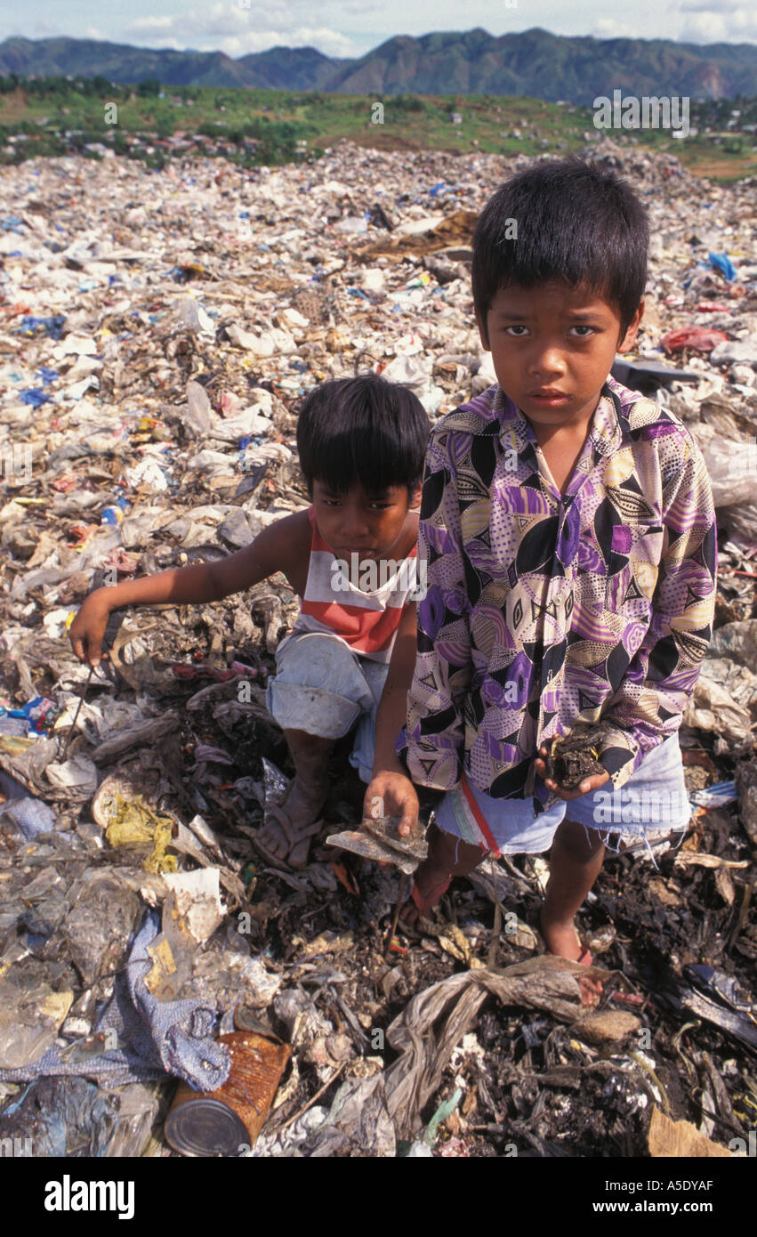 Impoverished poor young Boys scavenging the city dump for edible food ...