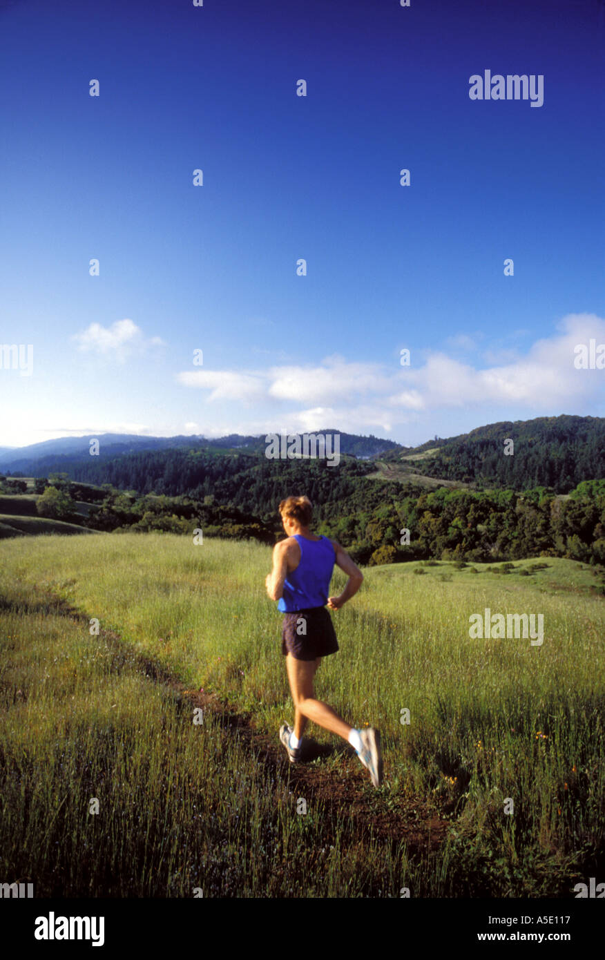 Man running down trail Stock Photo - Alamy