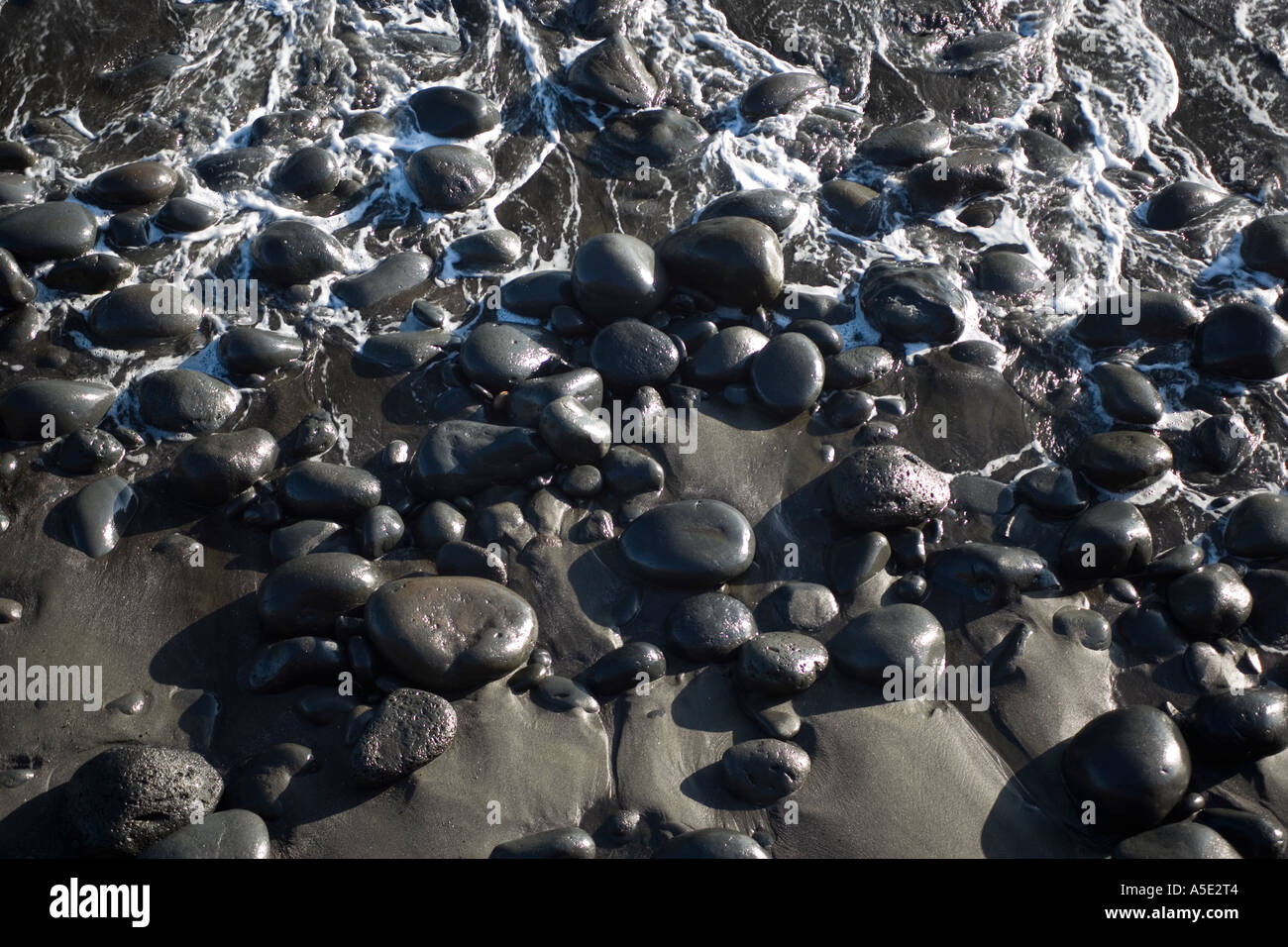 Pepples on Beach with Wave Stock Photo - Alamy