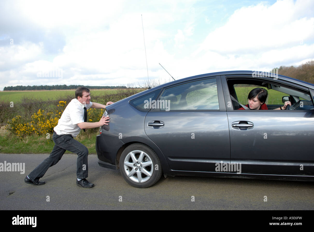 Male pushing broken down car Stock Photo - Alamy