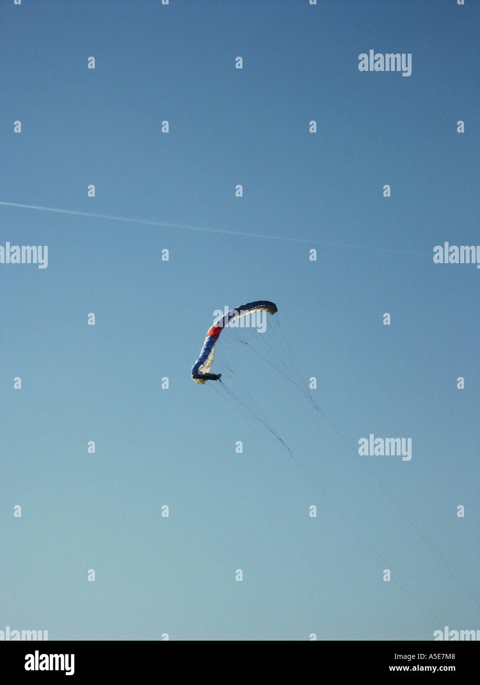 The canopy of a large kite flying against a blue sky in the UK Stock ...
