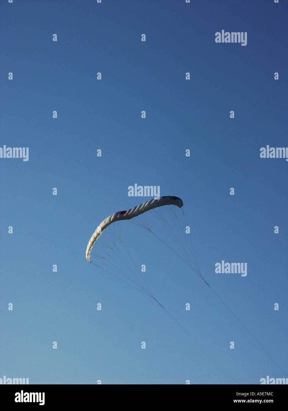 The canopy of a large kite flying against a blue sky in the UK Stock ...