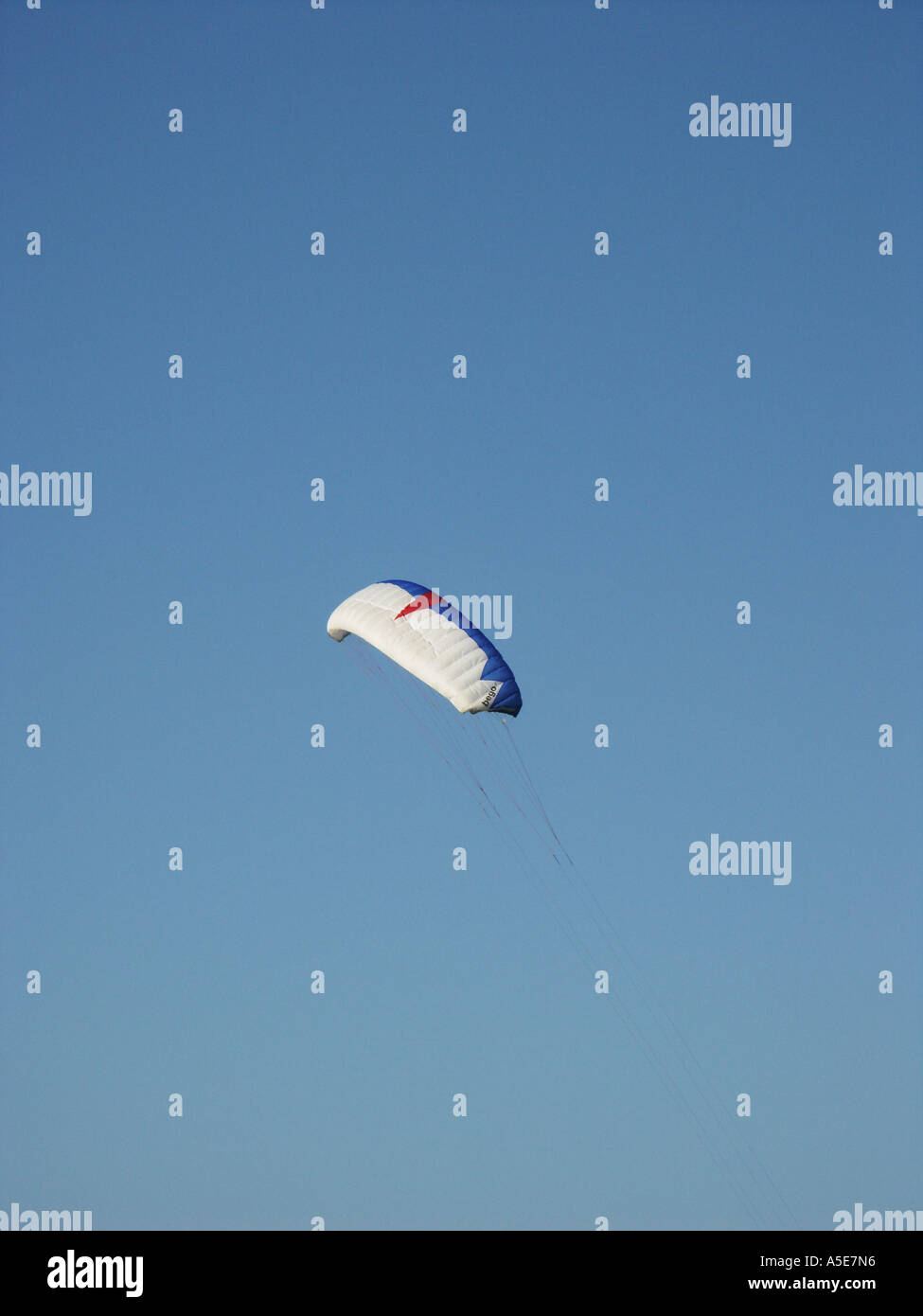 The canopy of a large kite flying against a blue sky in the UK Stock ...