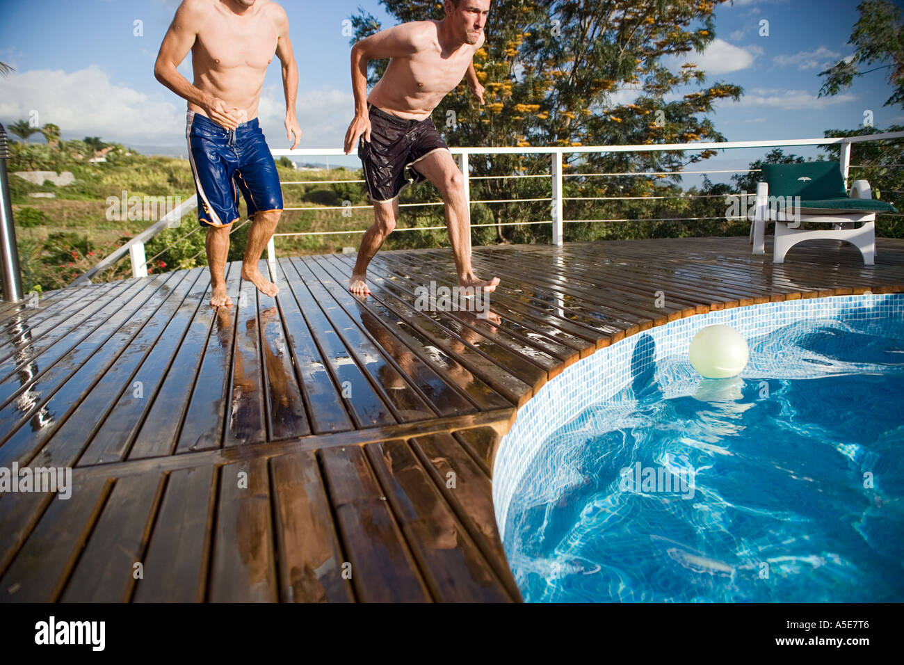 Two Men Running and Jumping into Swimming Pool Stock Photo - Alamy