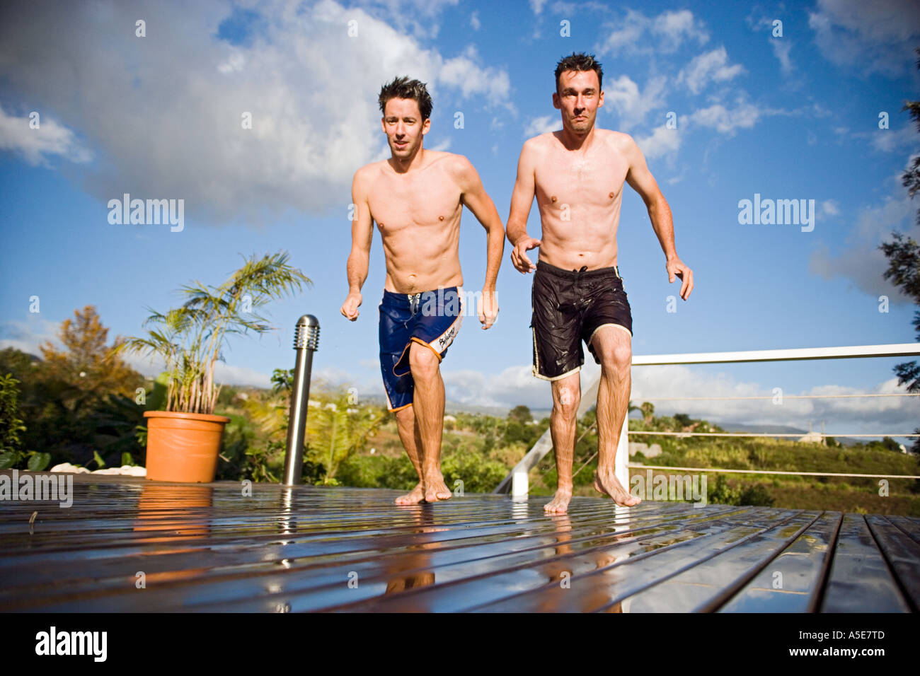 Two Men Running and Jumping into Swimming Pool Stock Photo - Alamy