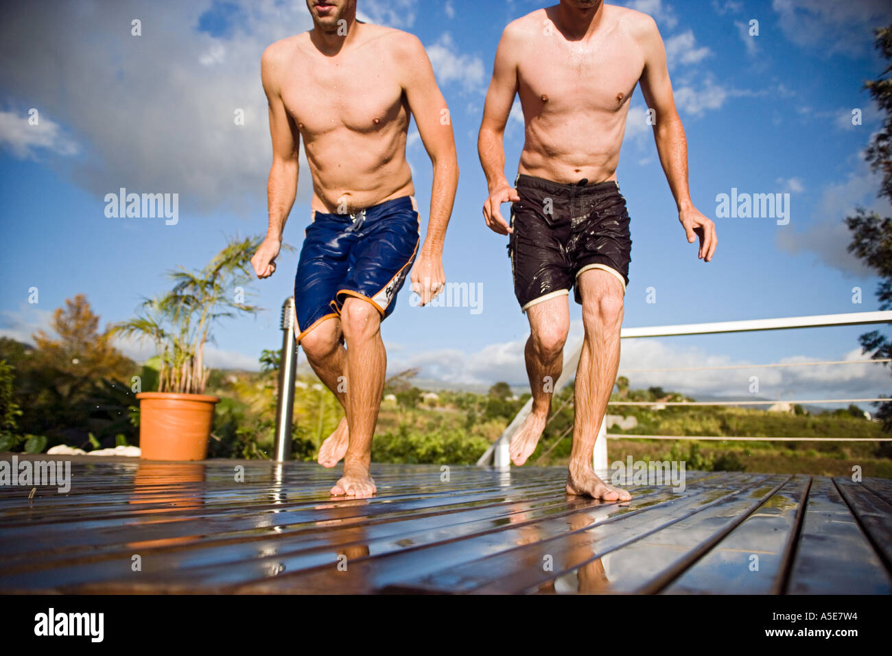 Two Men Running and Jumping into Swimming Pool Stock Photo - Alamy