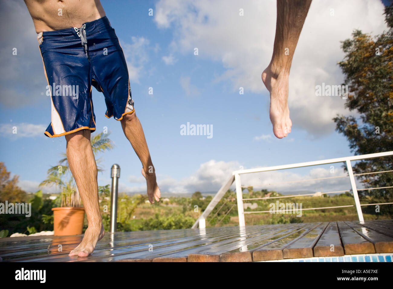 Two men Jumping into swimming pool Stock Photo - Alamy