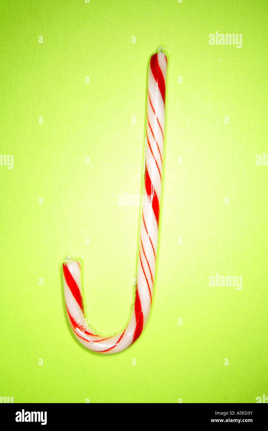 Candy cane on green background Stock Photo - Alamy