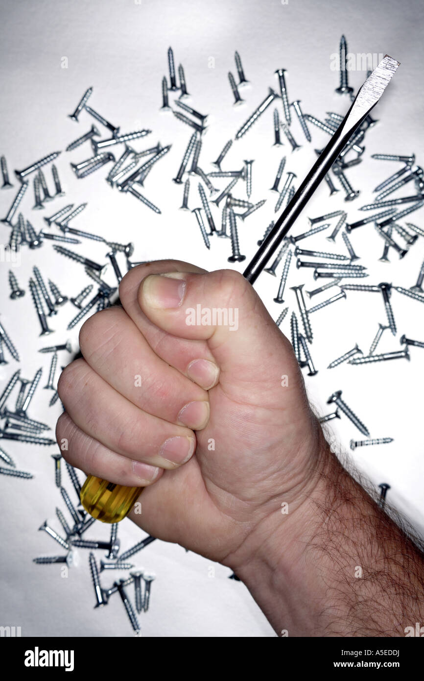 Hand holding screwdriver in front of screws Stock Photo - Alamy