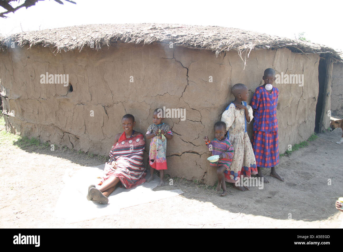 Masai children relax in the shade by their mud hut home on the Masai Mara in Kenya Stock Photo ...
