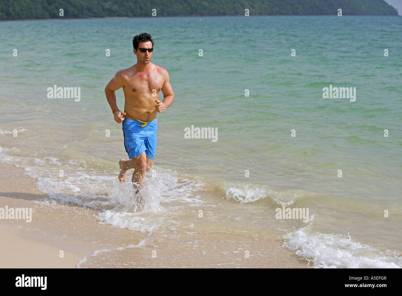 Male jogging on exotic beach hi-res stock photography and images - Alamy
