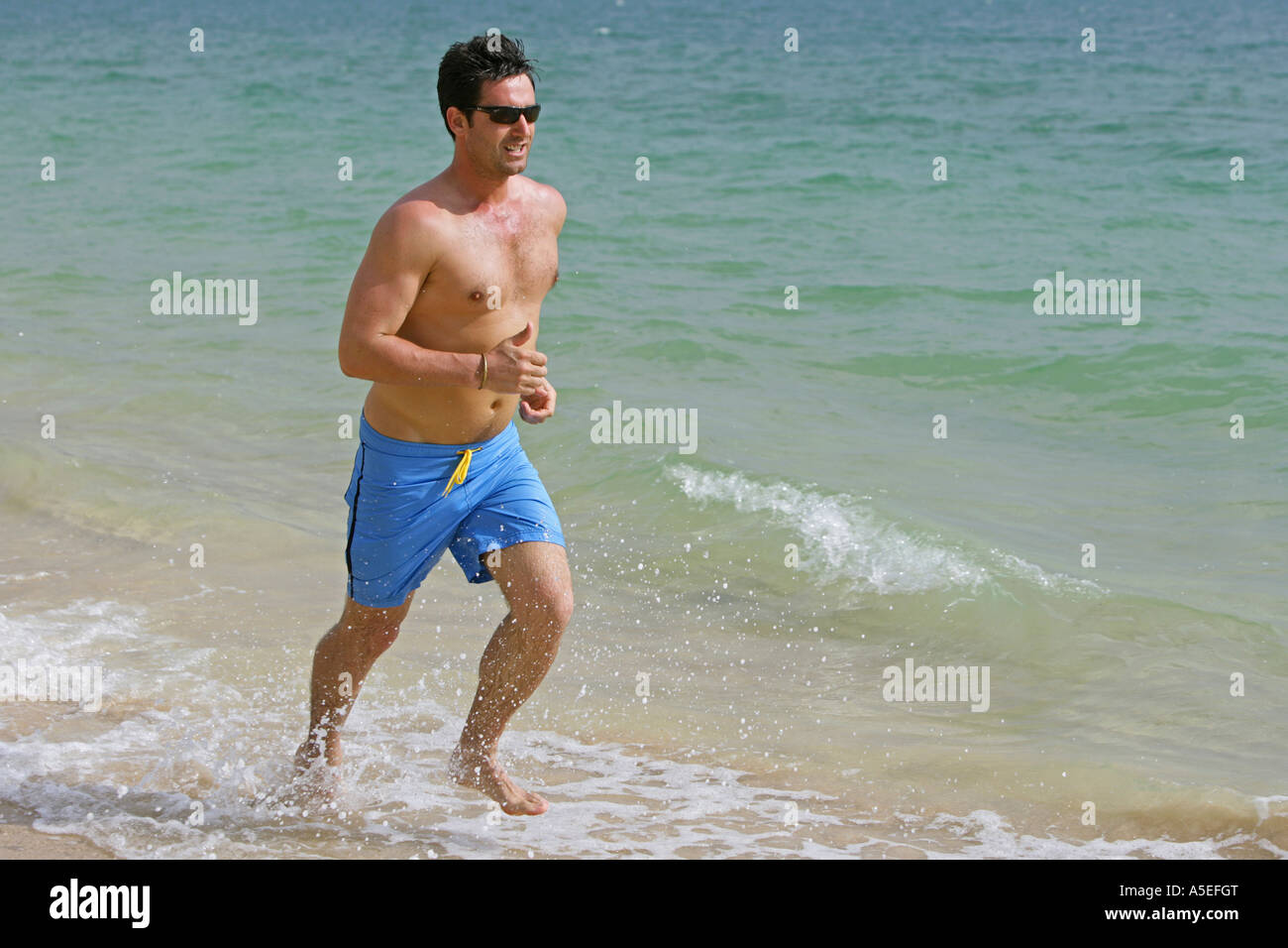 Male jogging on exotic beach hi-res stock photography and images - Alamy