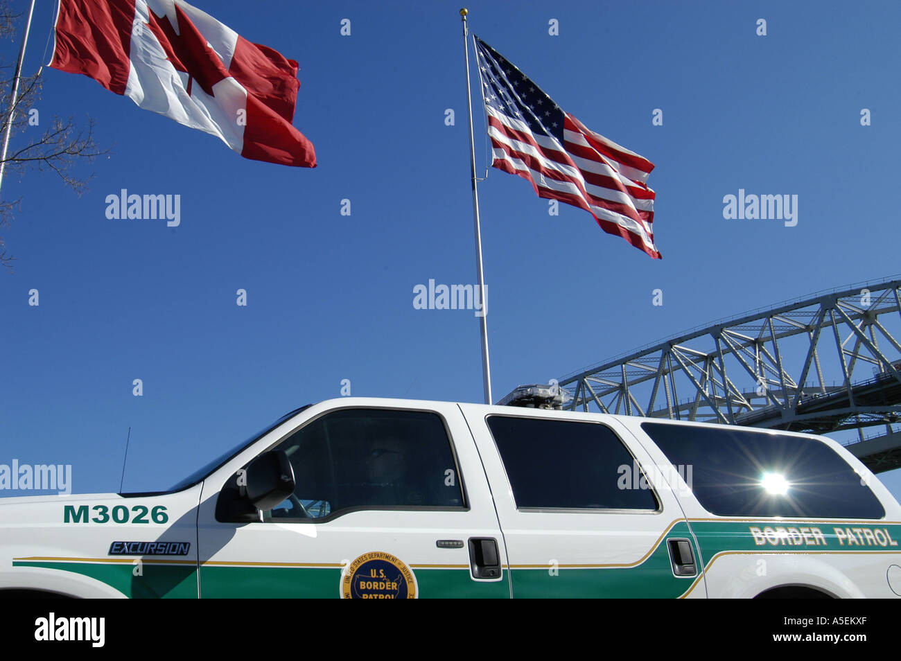 USA, Candadian flags flying over US Border Patrol SUV, Blue Water ...