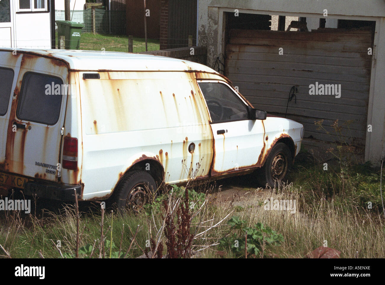 old rusty abandoned van by house Stock Photo - Alamy