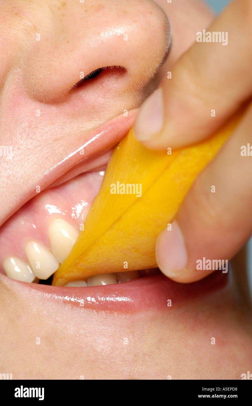 peachy bites woman biting into a piece of peach Stock Photo - Alamy