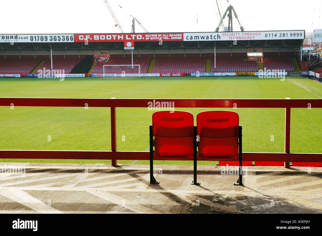 Isolated pair of red spectator seats on the terrace of Rotherham United ...