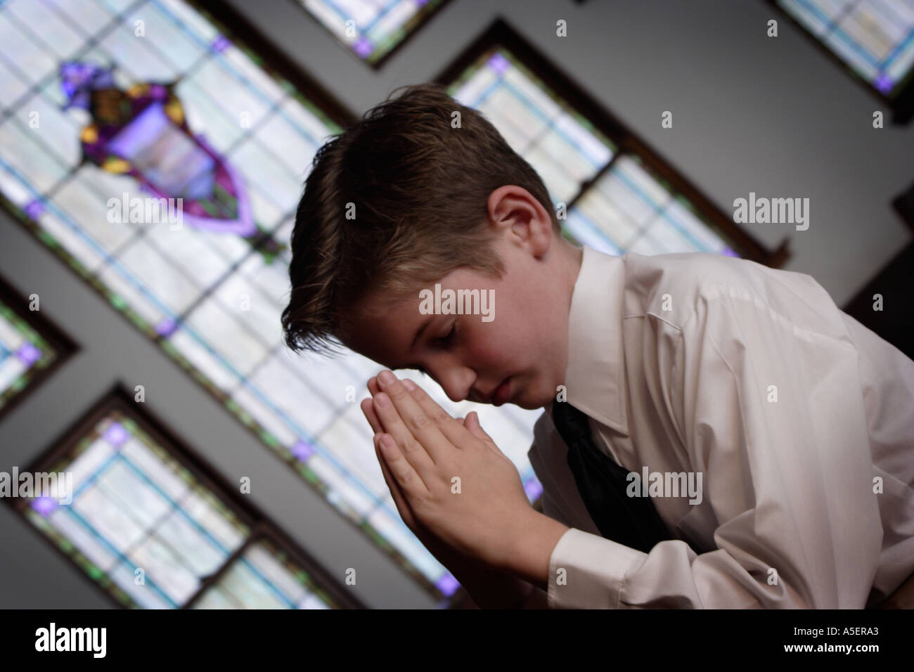 Boy praying in church environment Stock Photo - Alamy