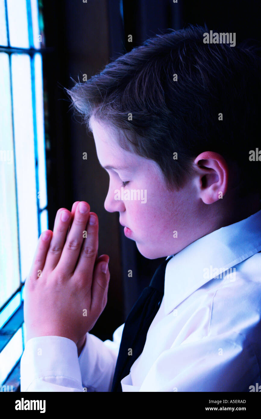 Boy praying in church environment Stock Photo - Alamy