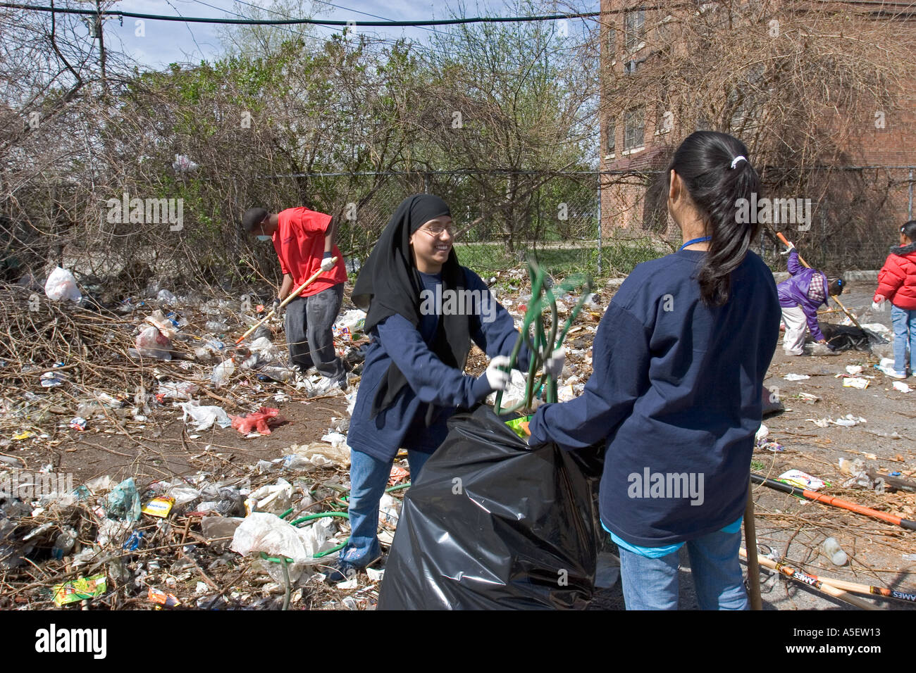 High School Volunteers Clean Grounds of Homeless Shelter Stock Photo ...