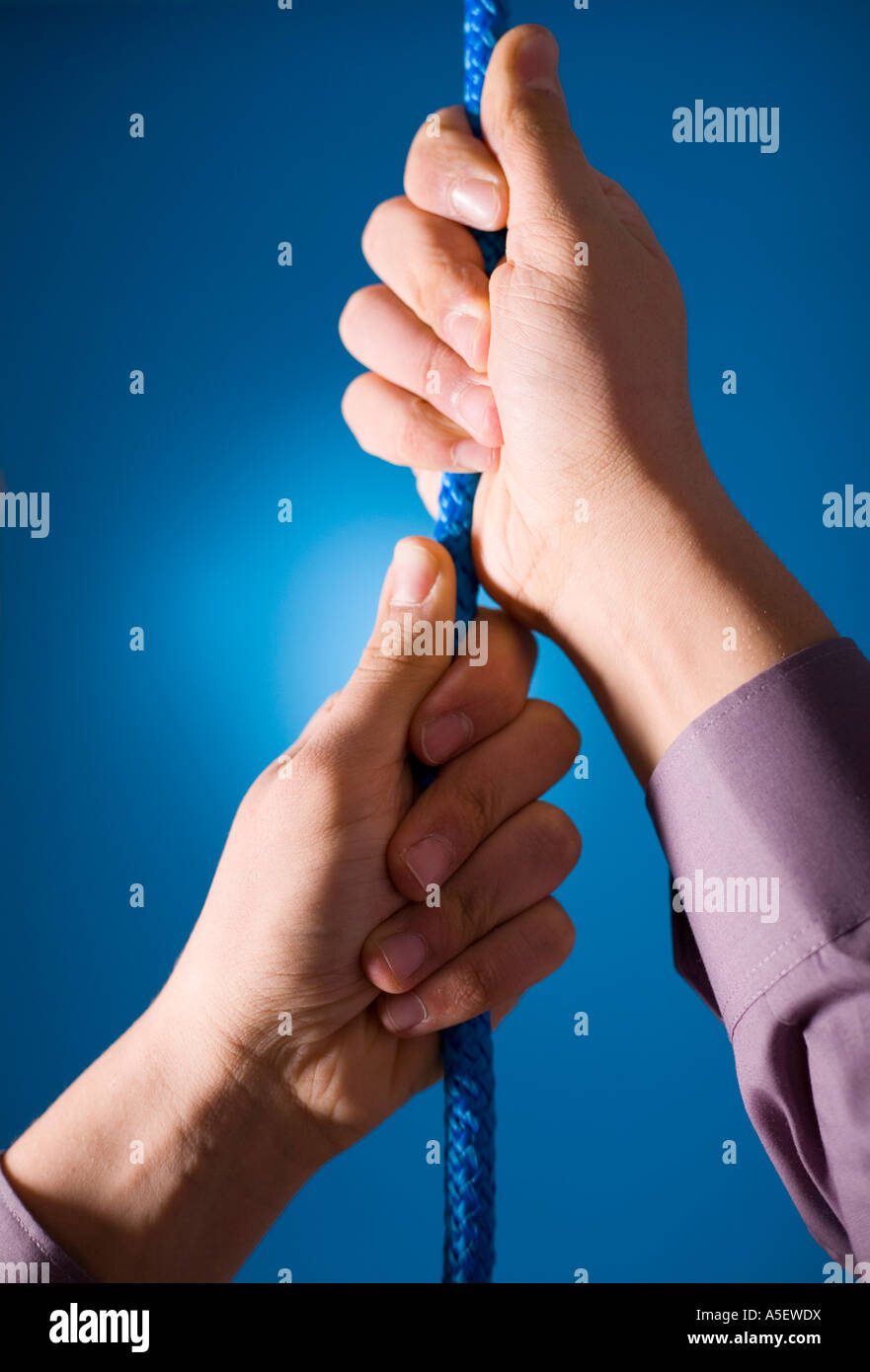 Man's hands holding blue rope Blue background in studio Stock Photo - Alamy