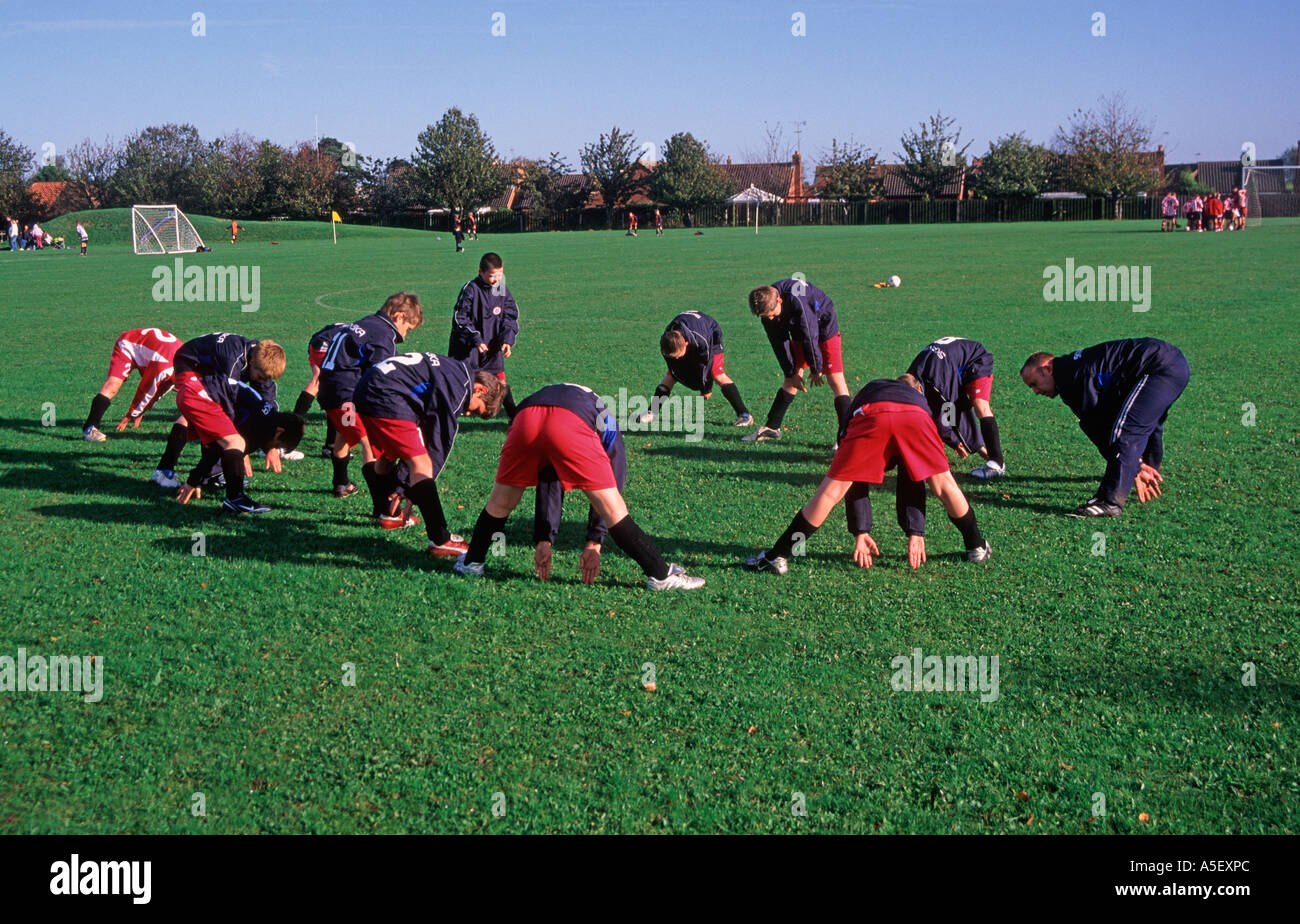 Team coach doing warm up exercises with boys football team Stock Photo ...